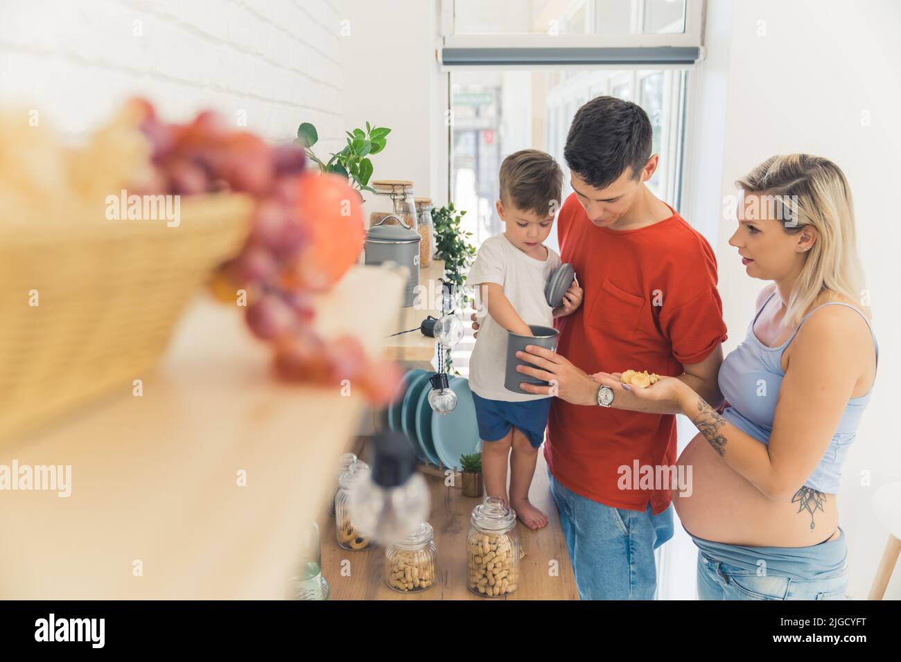 little boy checking things in the kitchen with his parents, family ...