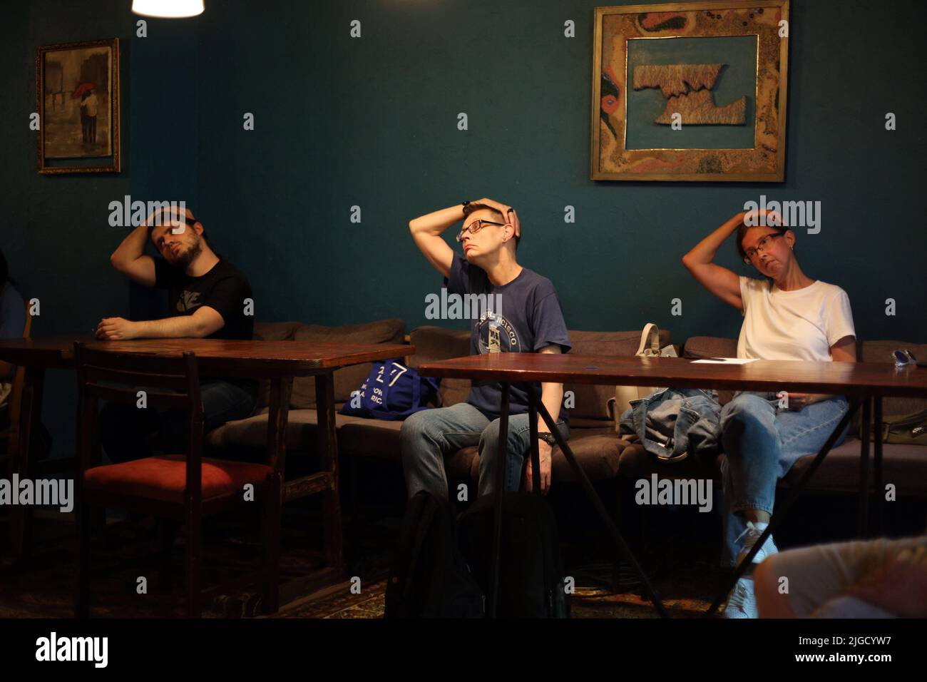 Conversational club members are seen in a classroom. The conversation ...