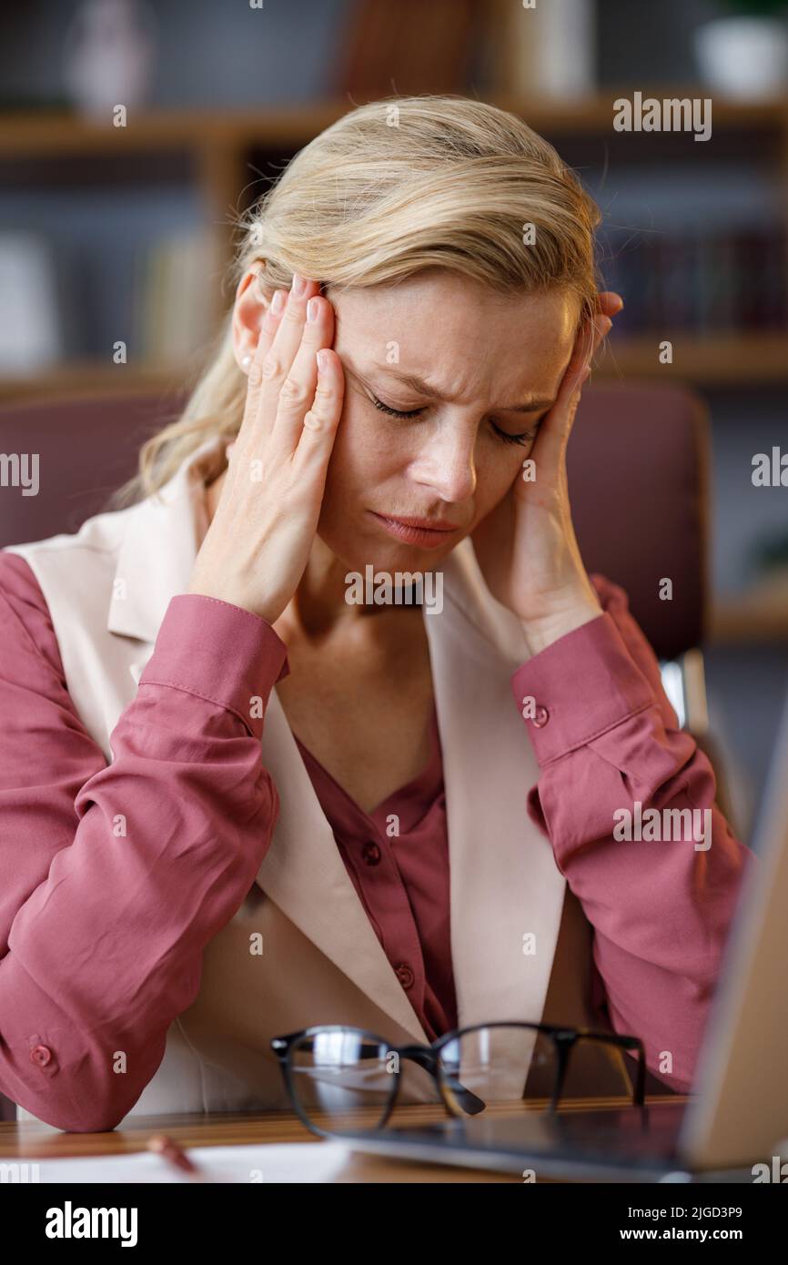 Tired businesswoman after exhausting paperwork taking off eyeglasses ...