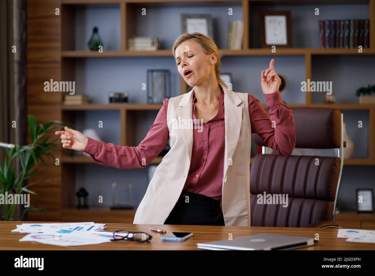 Female trader dancing at workplace. Happy businesswoman got positive ...