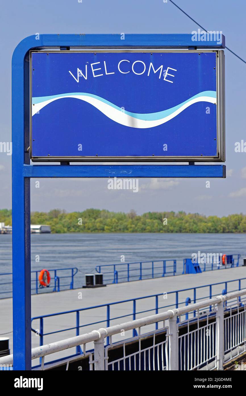 Big blue welcome sign board at river coast Stock Photo - Alamy