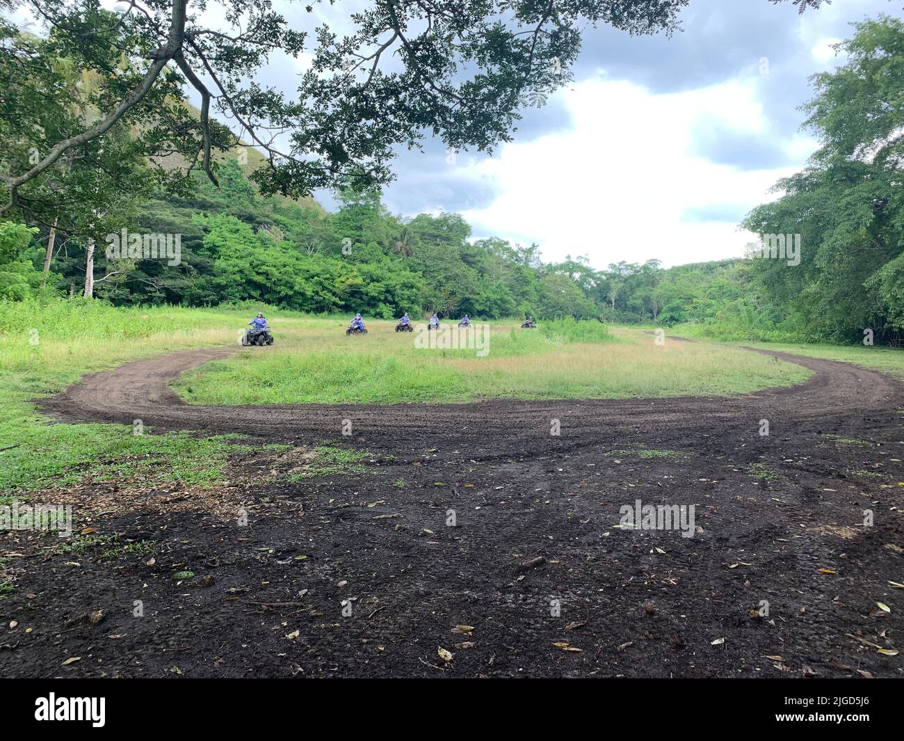 A group of people driving quad bikes in an open green field Stock Photo ...