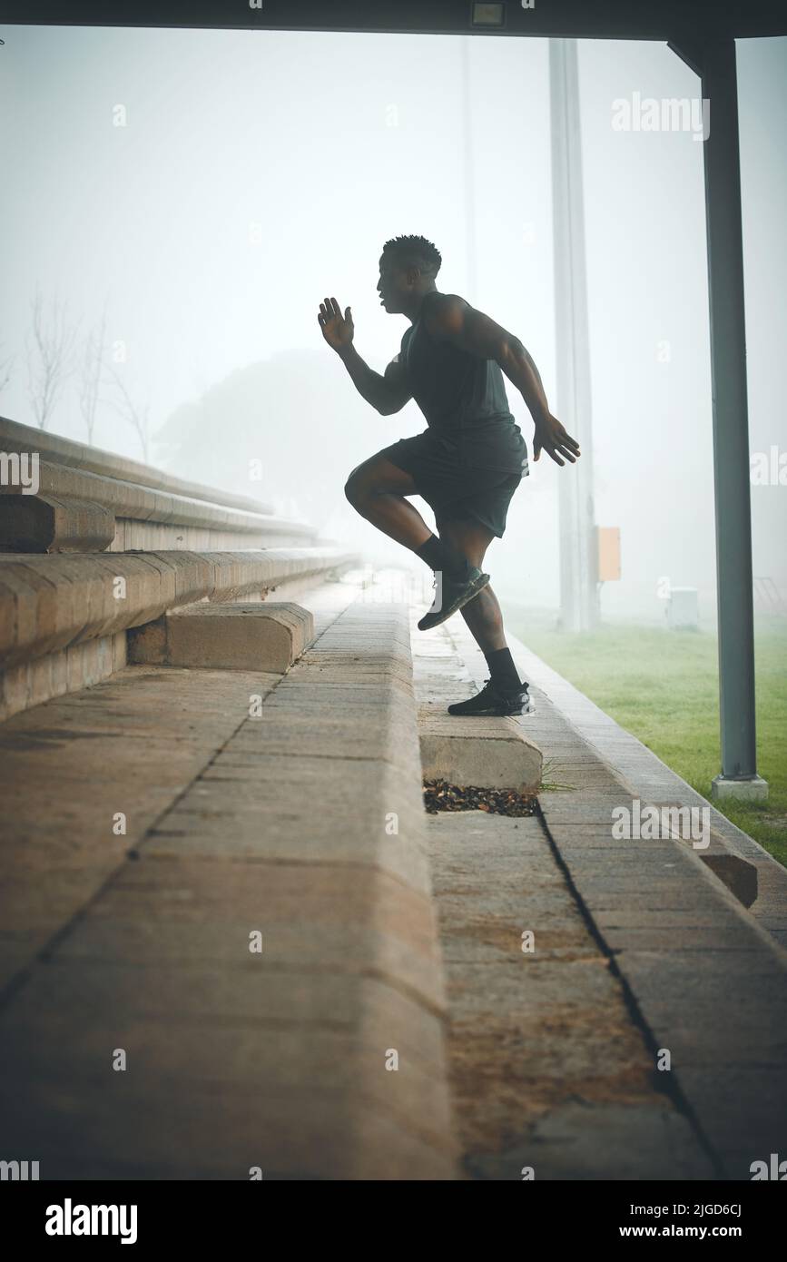 Building speed and endurance. a muscular young man running up steps ...