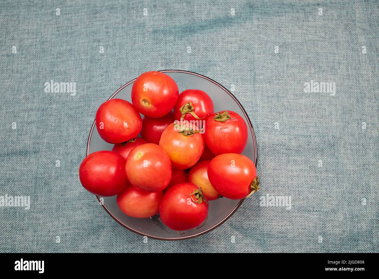 Red tomato in a glass bowl Stock Photo - Alamy