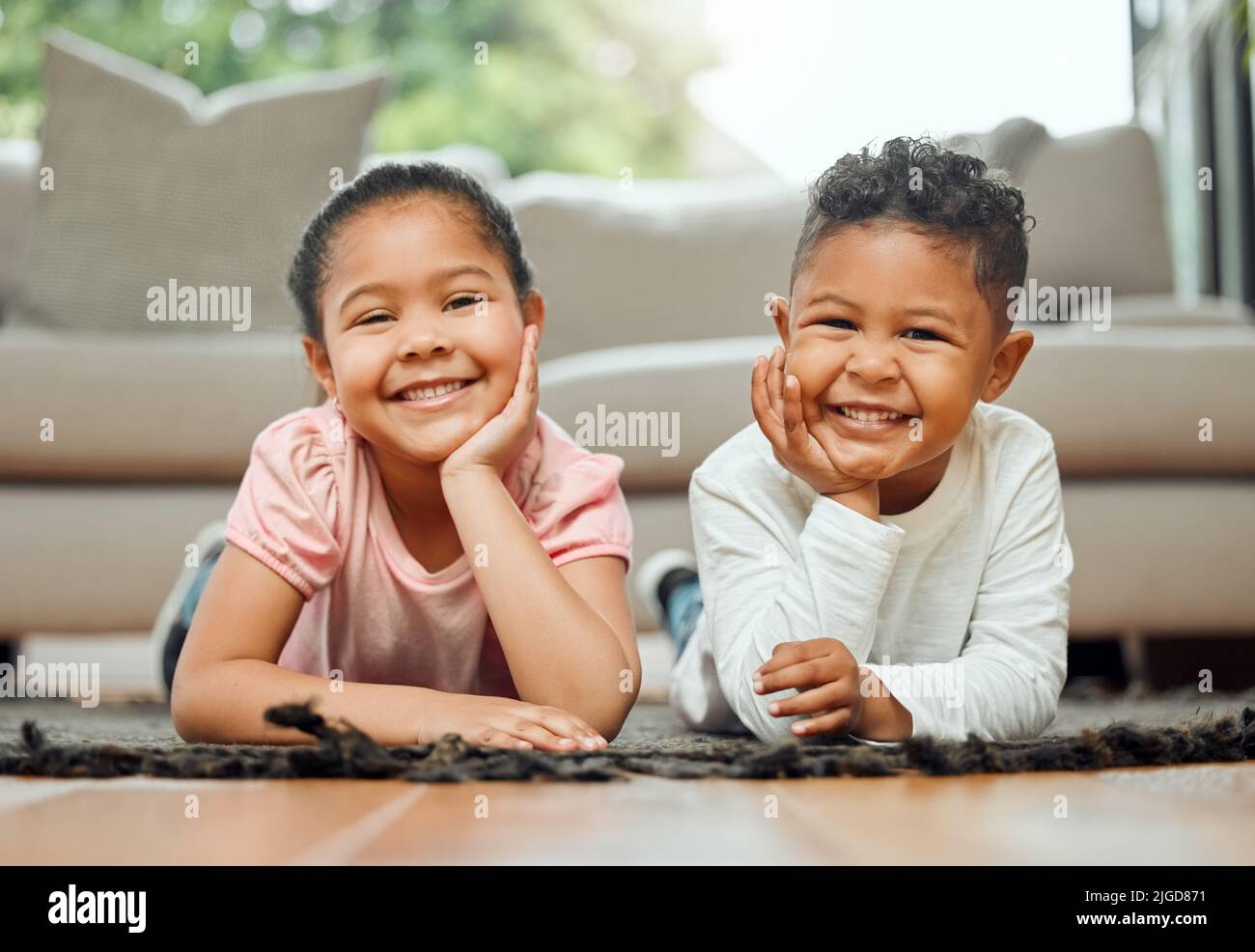Learning Together Portrait Of Two Young Siblings Lying On The Floor