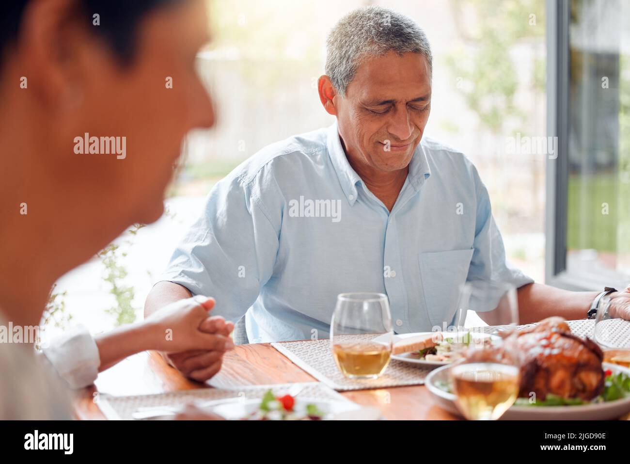 Lets bless the food. a family having lunch together at home Stock Photo ...