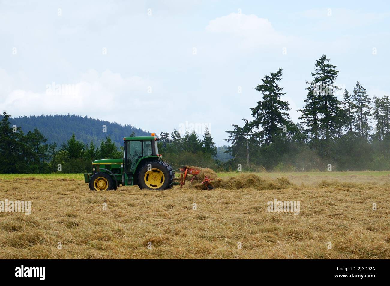Farm tractor mowing hay field Stock Photo - Alamy