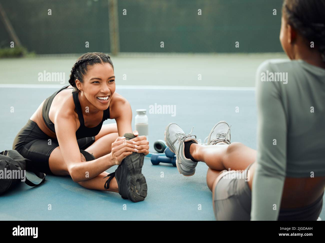 Dedicated to fitness. two attractive young female athletes warming up ...
