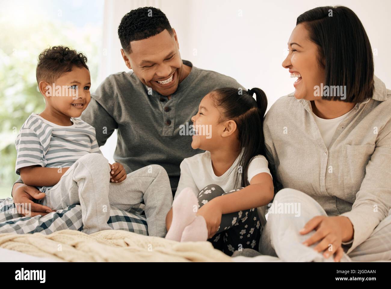 Our loving room. a beautiful young family talking and bonding in bed ...