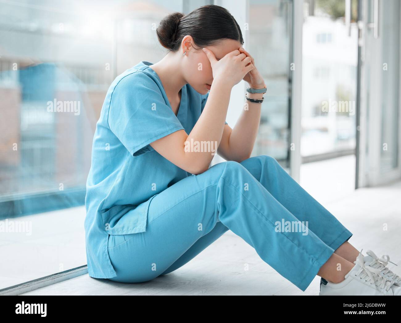 I cant cope with all the loss. a young female doctor looking stressed ...
