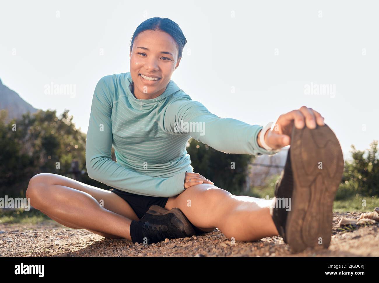 A good stretch to warm up the muscles. a young woman stretching her ...