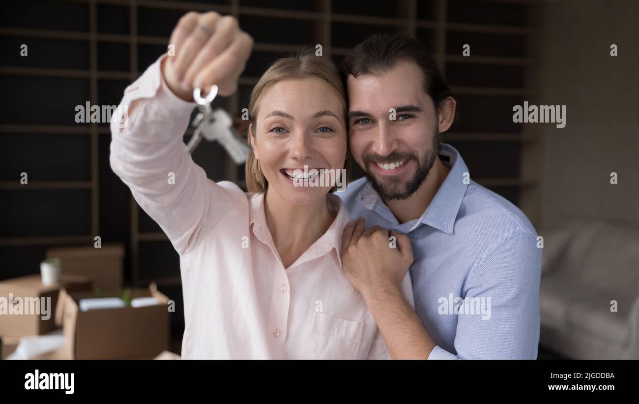Happy excited married couple showing keys at camera Stock Photo - Alamy