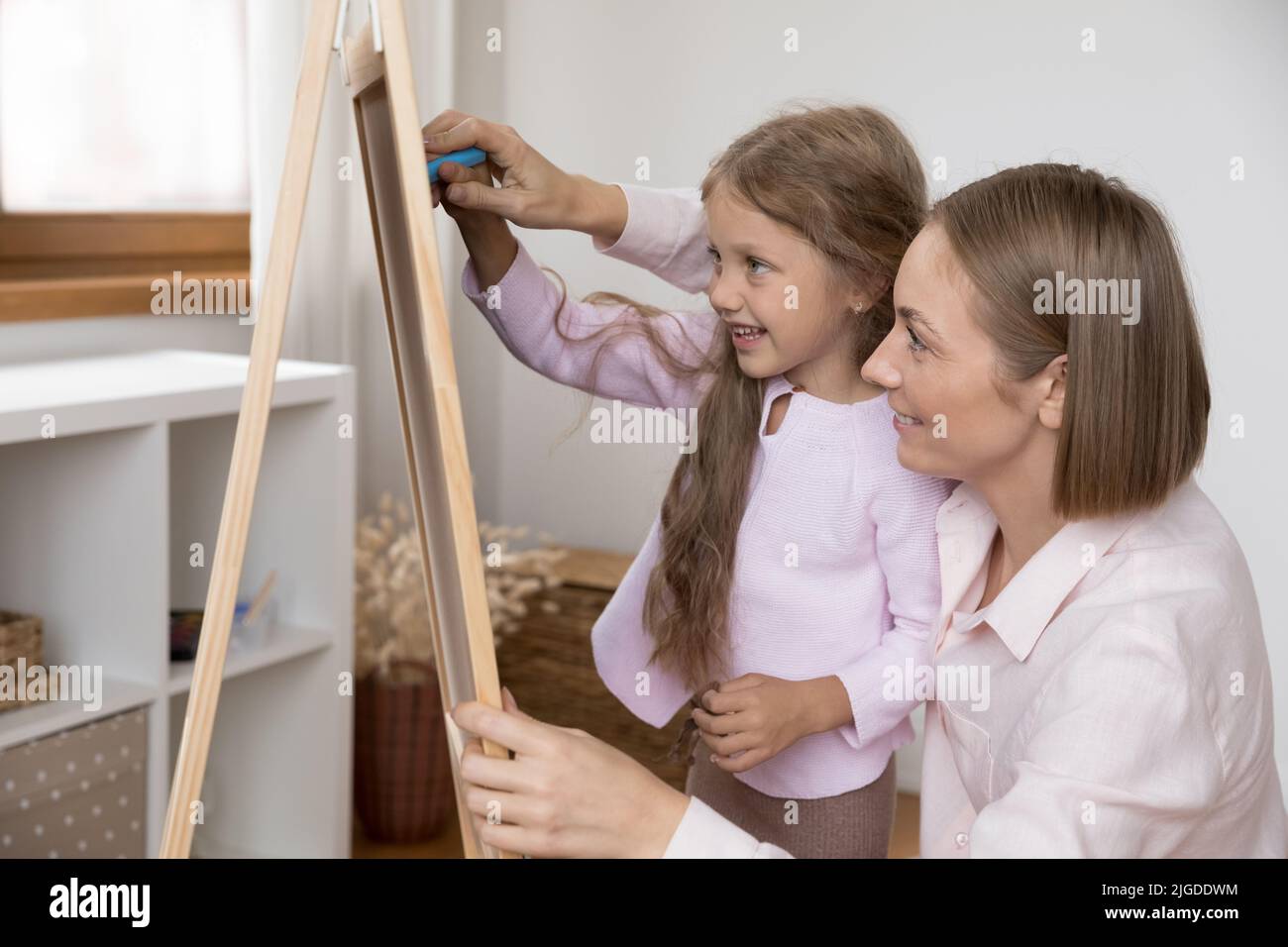 Happy loving caring mom teaching cheerful daughter kid to draw Stock ...