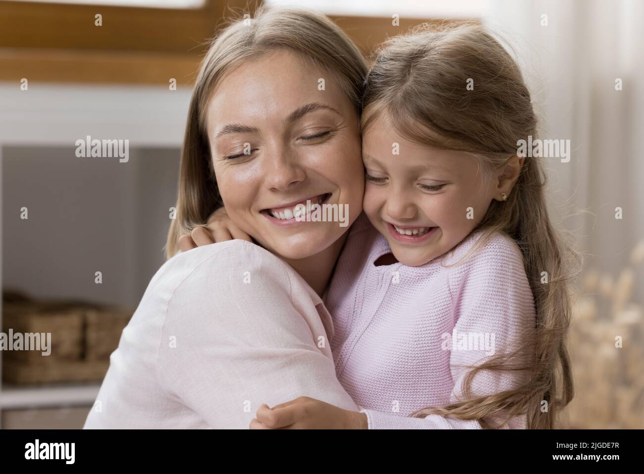 Happy loving mom hugging sweet little preschool daughter girl Stock ...