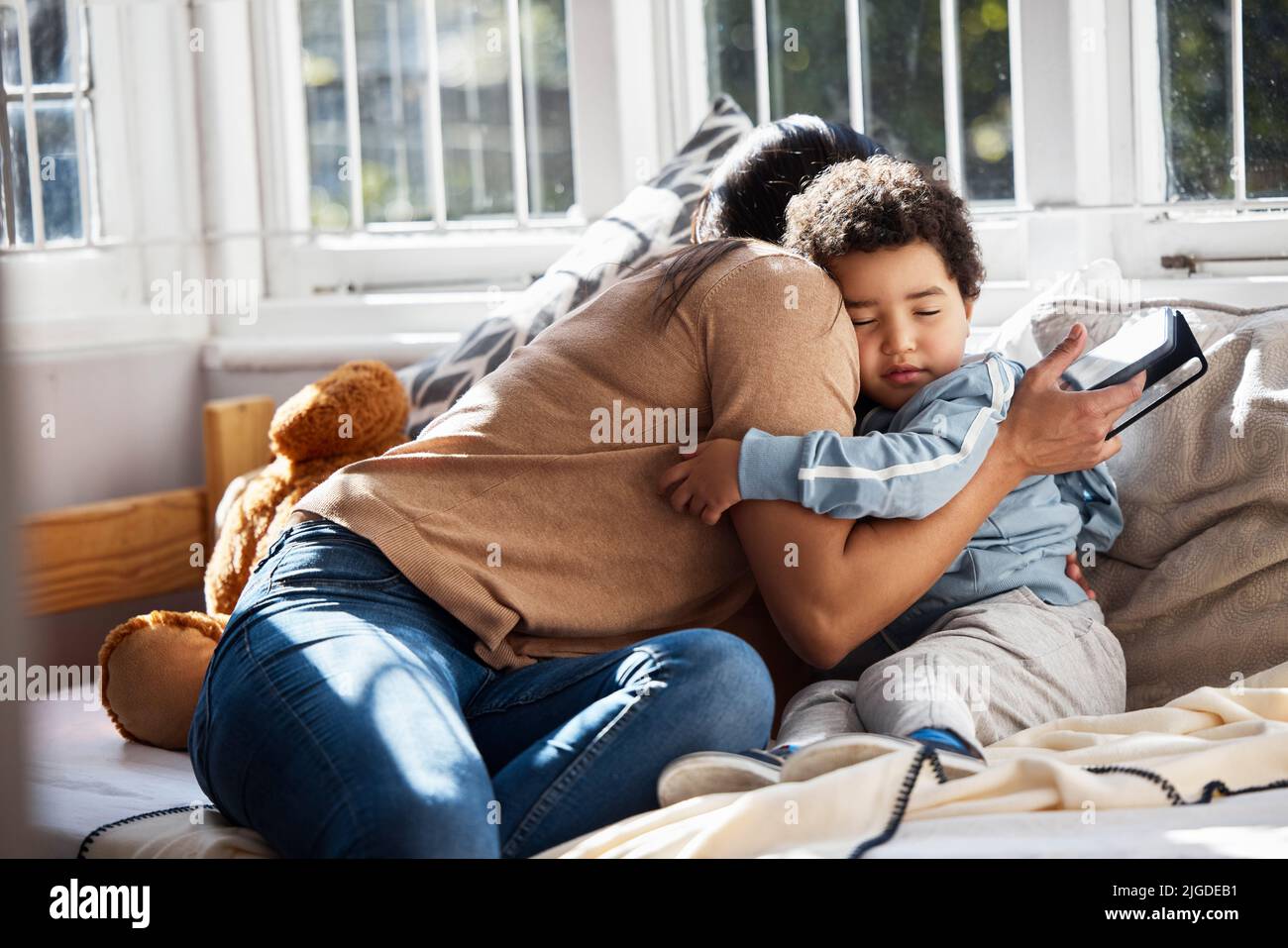 Can I get a hug. a young mother and son hugging at home Stock Photo - Alamy