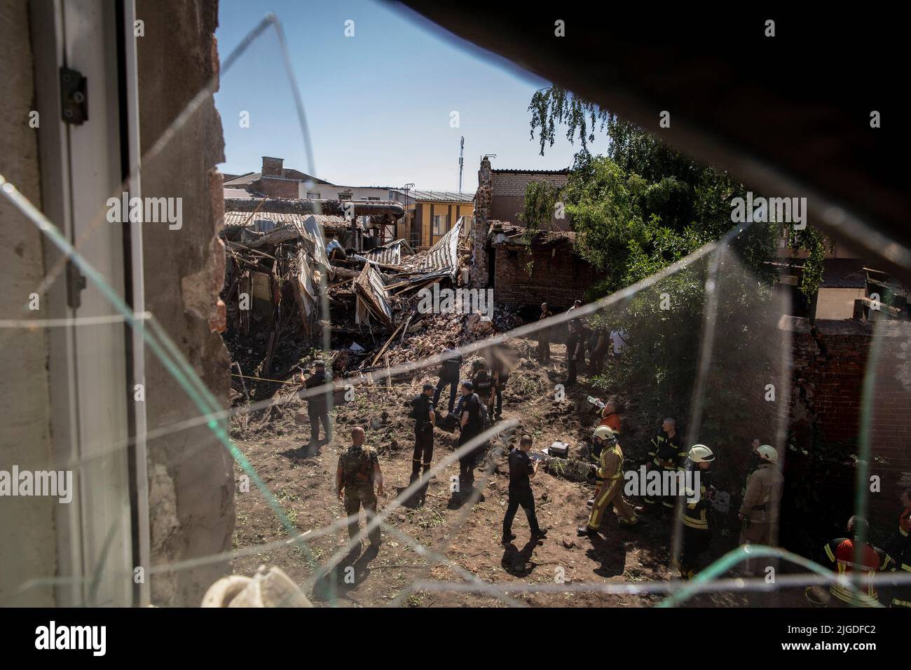A view of a missile strike scene from a broken glass window in Kharkiv ...