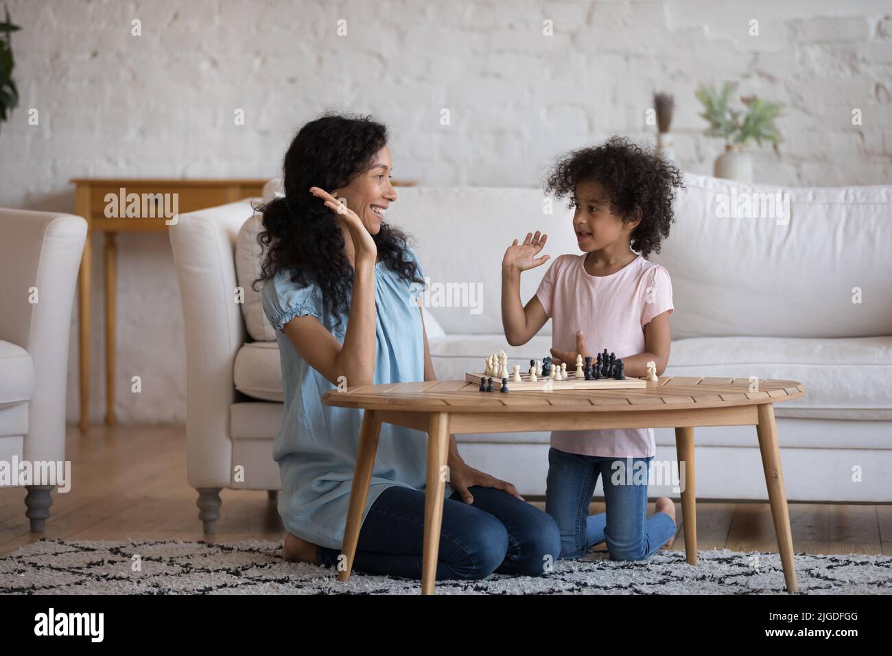 African mother giving high five, praises daughter for chess victory ...