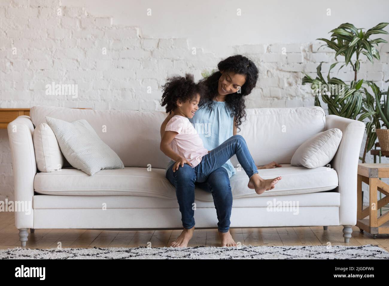 African daughter sits on mommy laps play together at home Stock Photo - Alamy