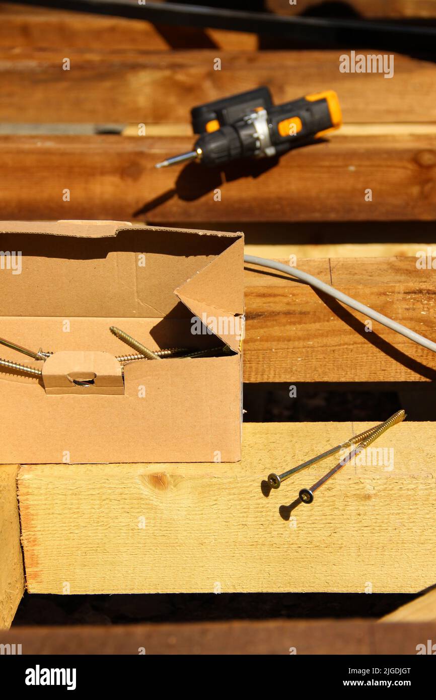 An open screw box lays on a wooden beam. Deck repair Stock Photo - Alamy