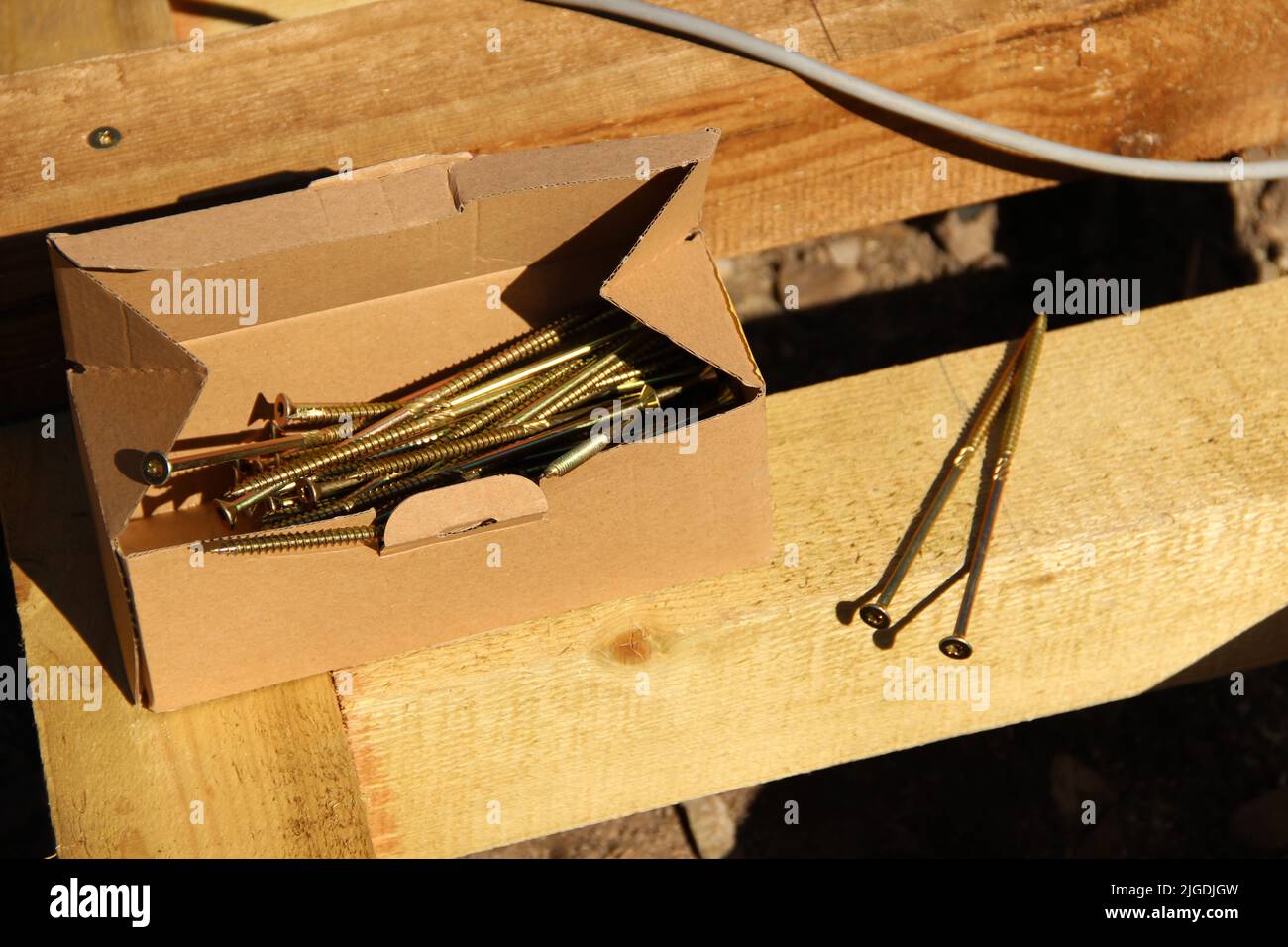 An open screw box lays on a wooden beam. Deck repair Stock Photo - Alamy