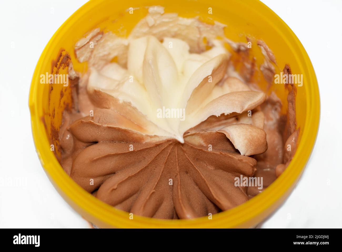 Frozen ice cream half vanilla and half chocolate in a plastic container ...