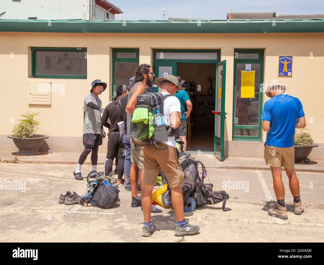 Pilgrims waiting for their albergue to open while walking the Camino de ...