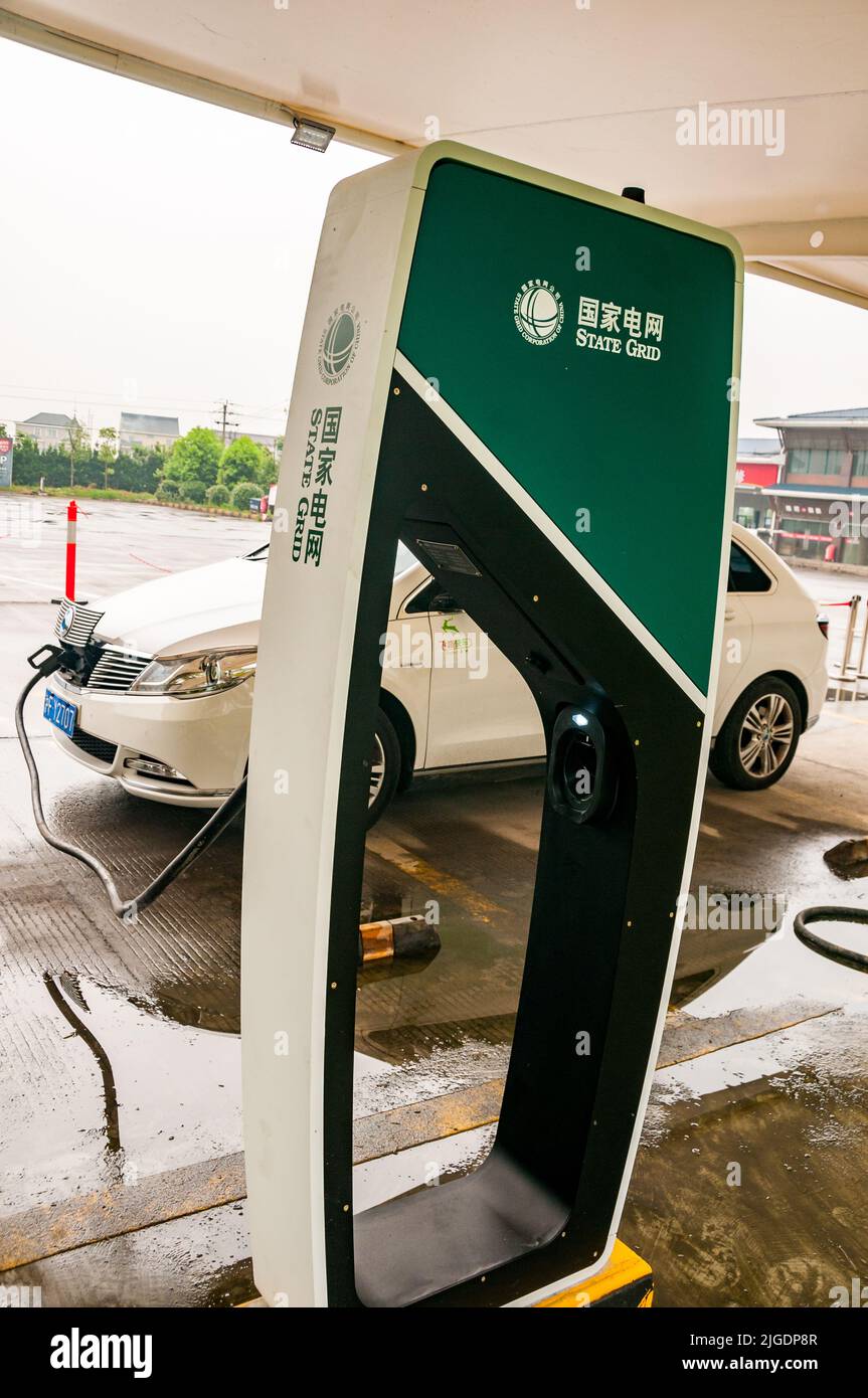 A Denza electric car being charged from a State Grid fast charger at ...