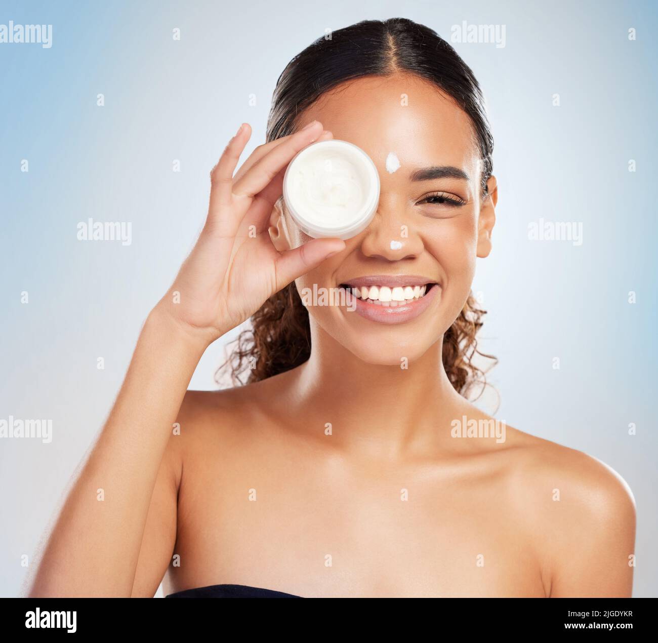Bringing out the lotion. a young woman applying cream to her face ...