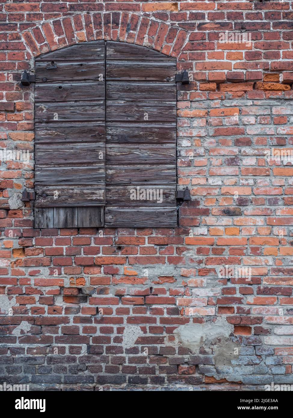 Red brick wall with wooden doors of old abandoned port warehouse ...