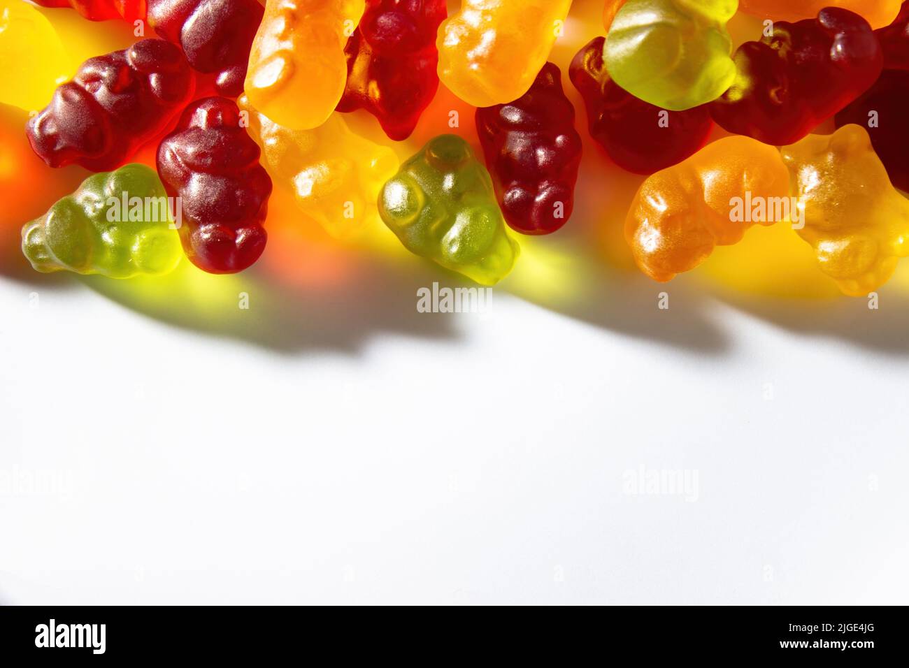 Gummy animals of different colors with fruit juice lie on top of the ...