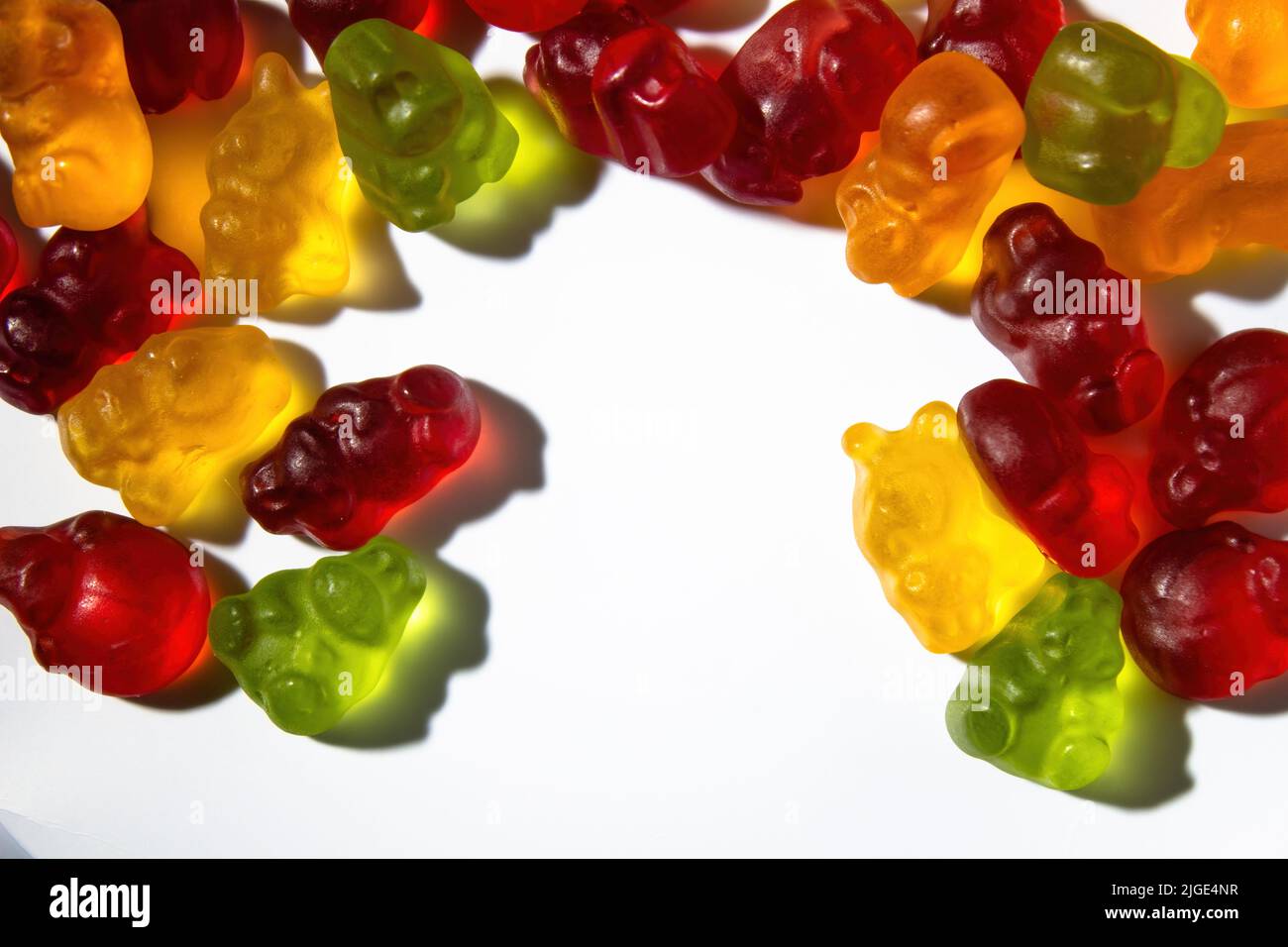 Marmalade animals of different colors with fruit juice lie on a white ...
