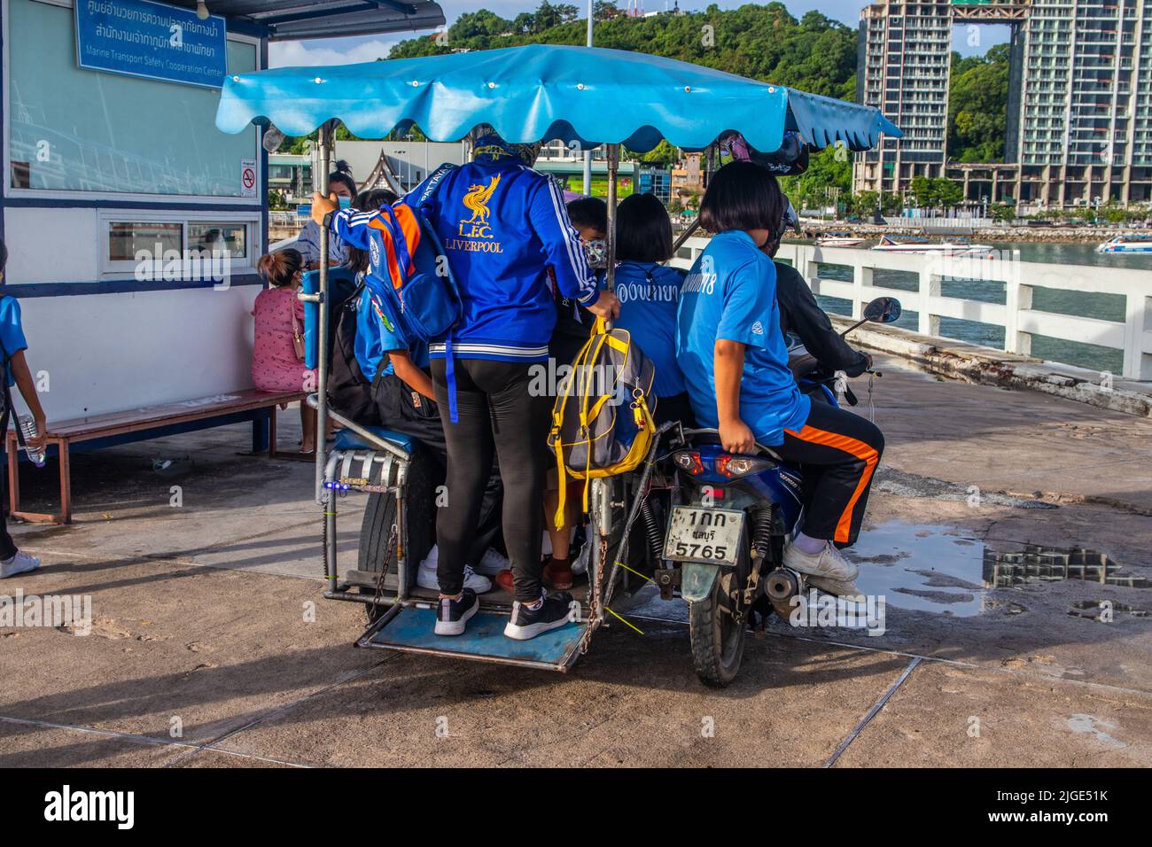 Several people are transported by a motorcycle taxi service in Thailand ...