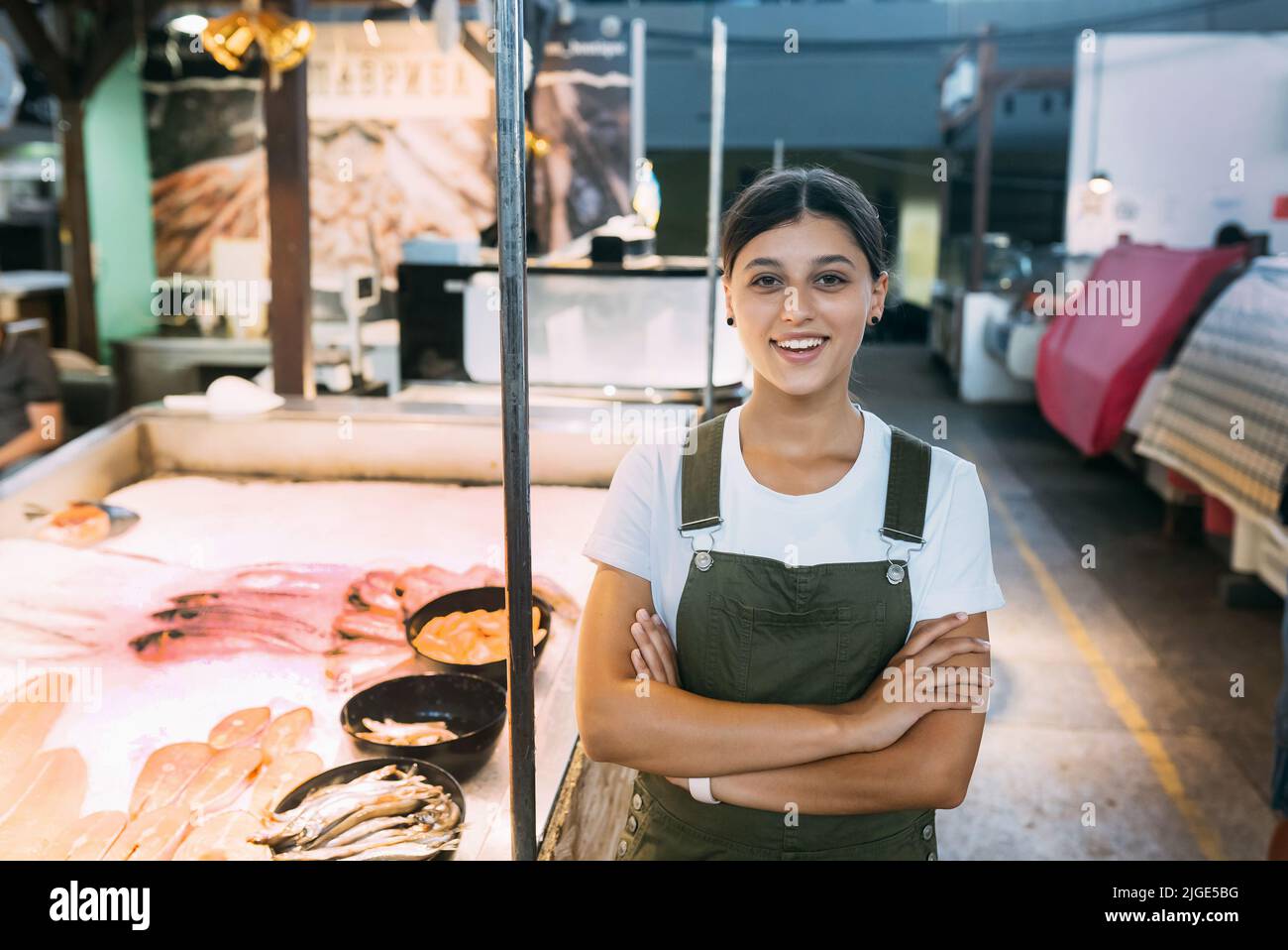 Female fishmonger standing near seafood shop counter Stock Photo - Alamy