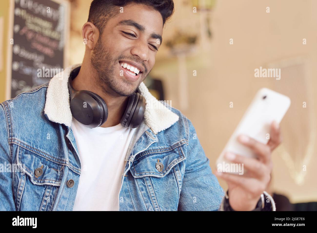 You make me smile. a young man using his smartphone to send a text ...