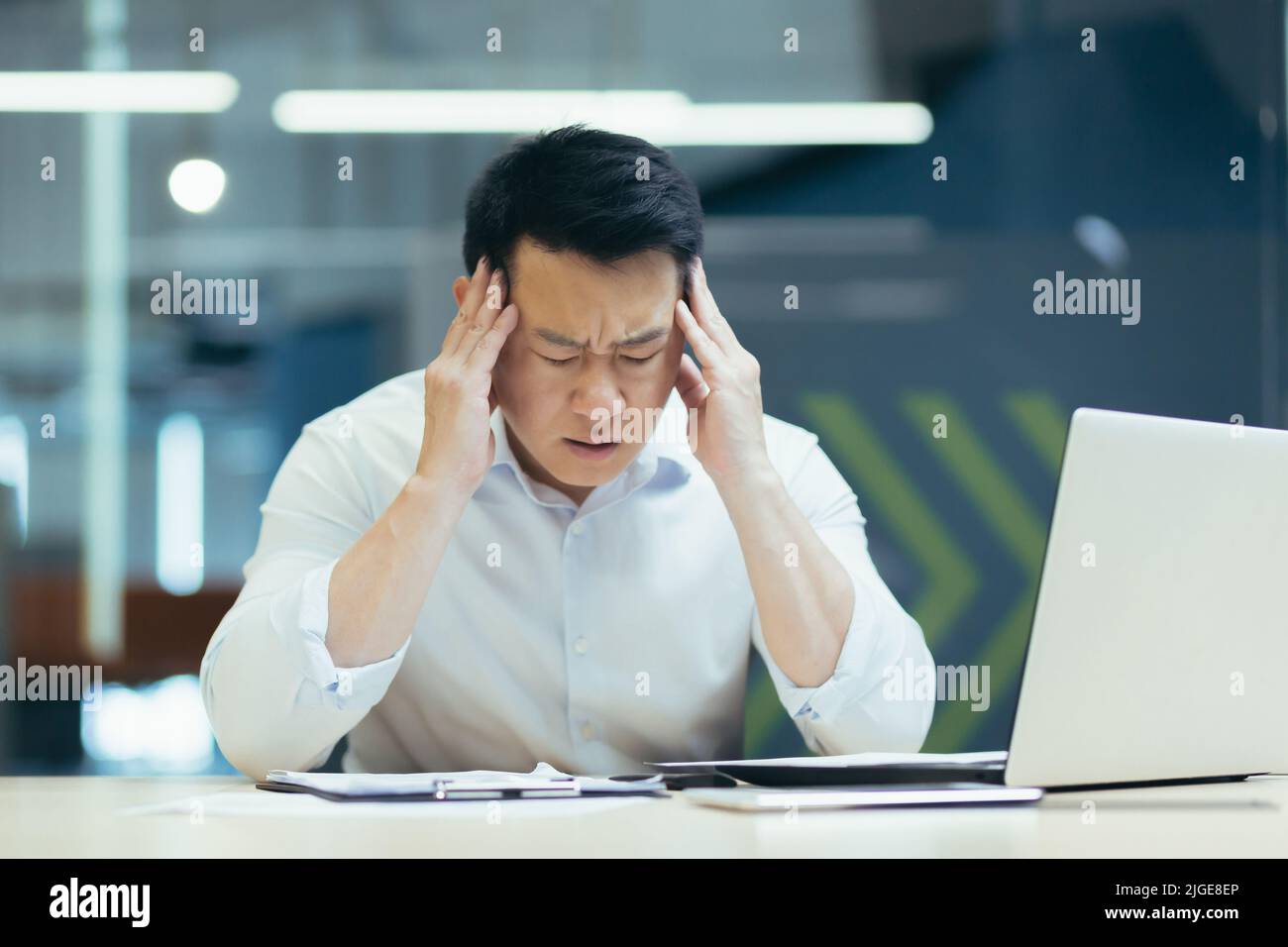 Upset and unhappy asian businessman reading documents and letter from ...