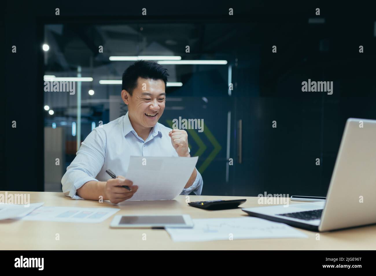 Successful and confident asian businessman reading bank letter and ...