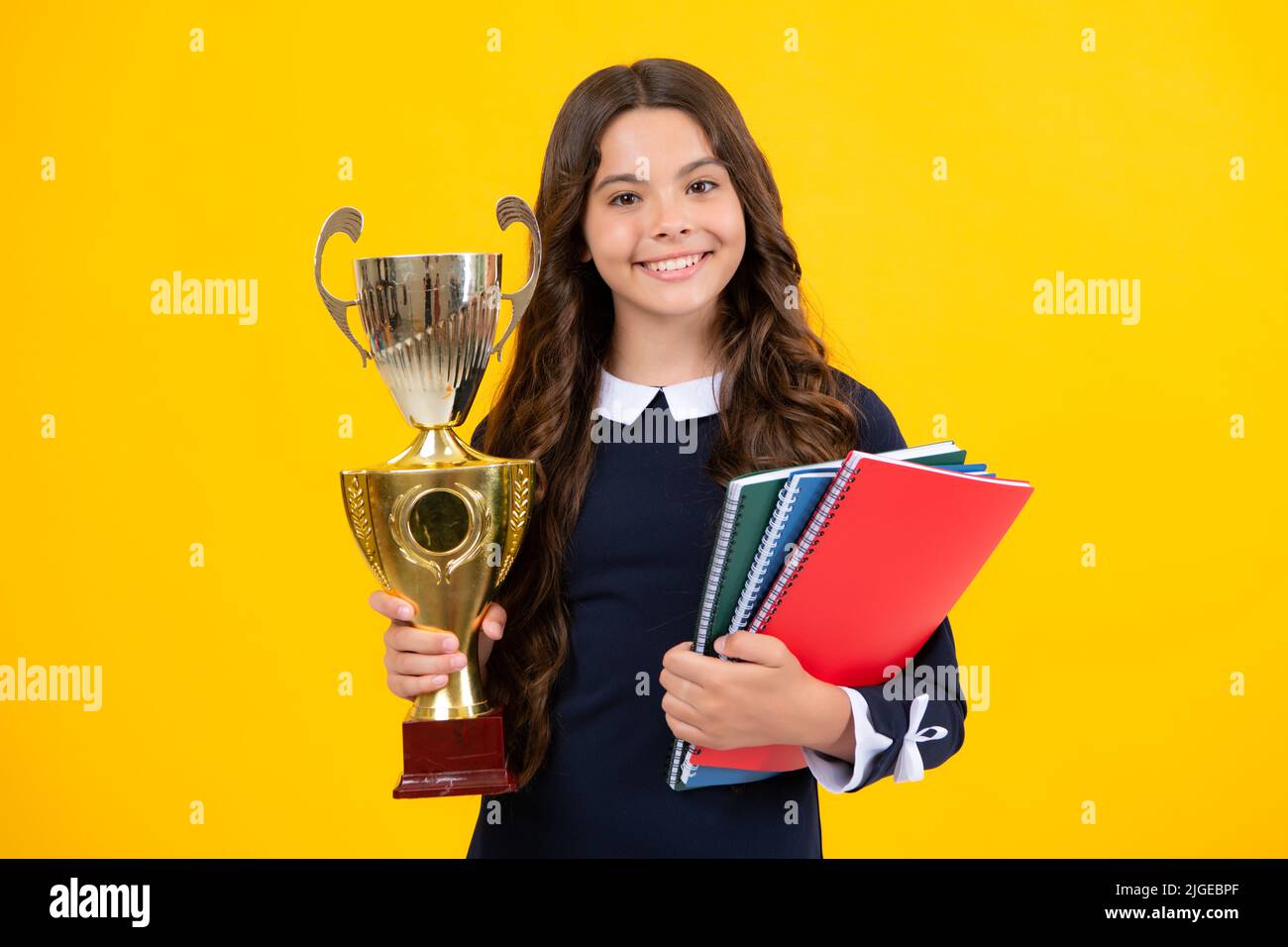 Teenager school girl with award winner trophy. Child hold books with ...
