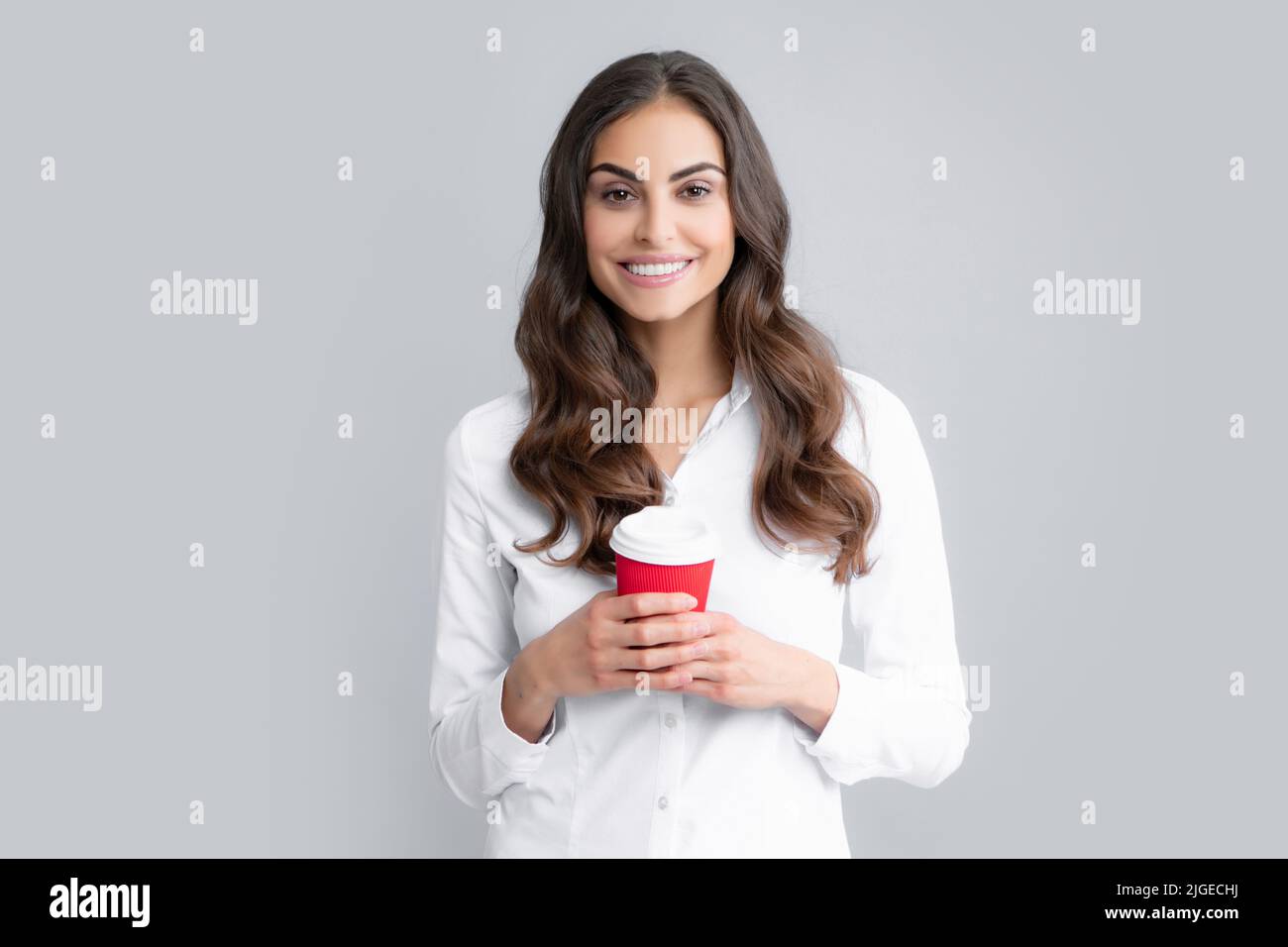 Portrait of a pretty woman holding takeaway coffee cup isolated over ...