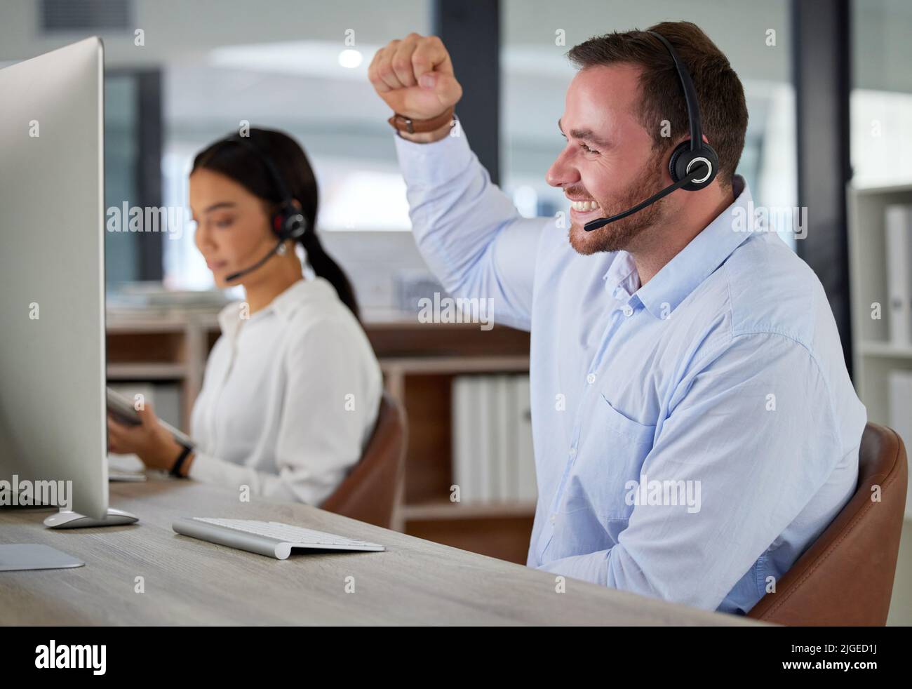 Thats what I love to hear. a young man cheering while using a computer ...