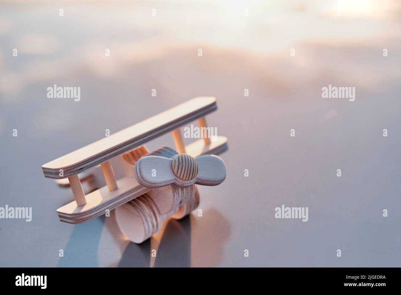 Wooden toy light aircraft biplane with propeller on glossy surface ...
