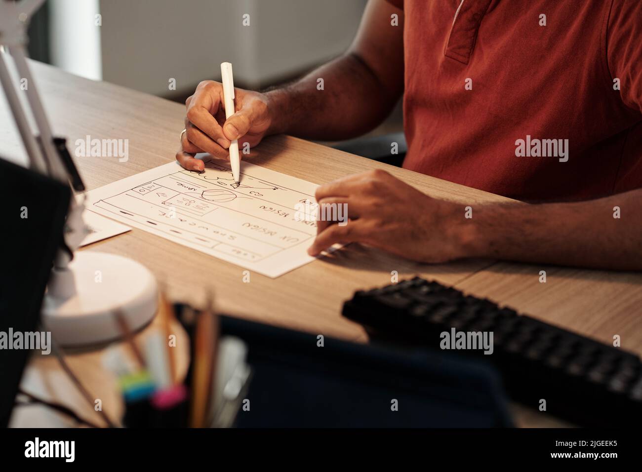 Hands of UI designer or front end developer drawing wireframe on paper ...
