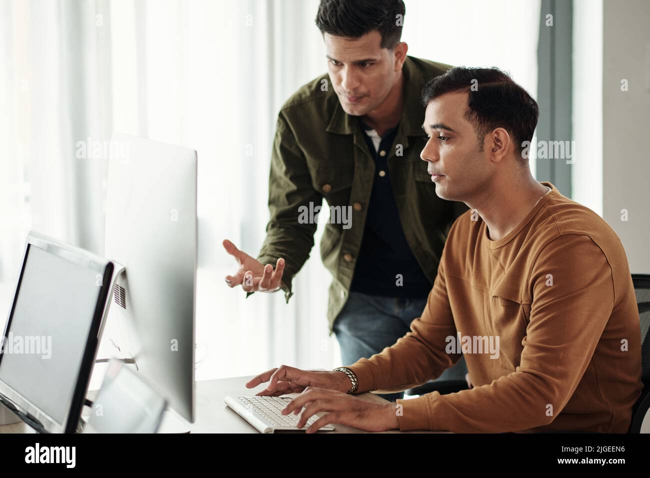 Lead developer helping junior developer with troubleshooting software ...