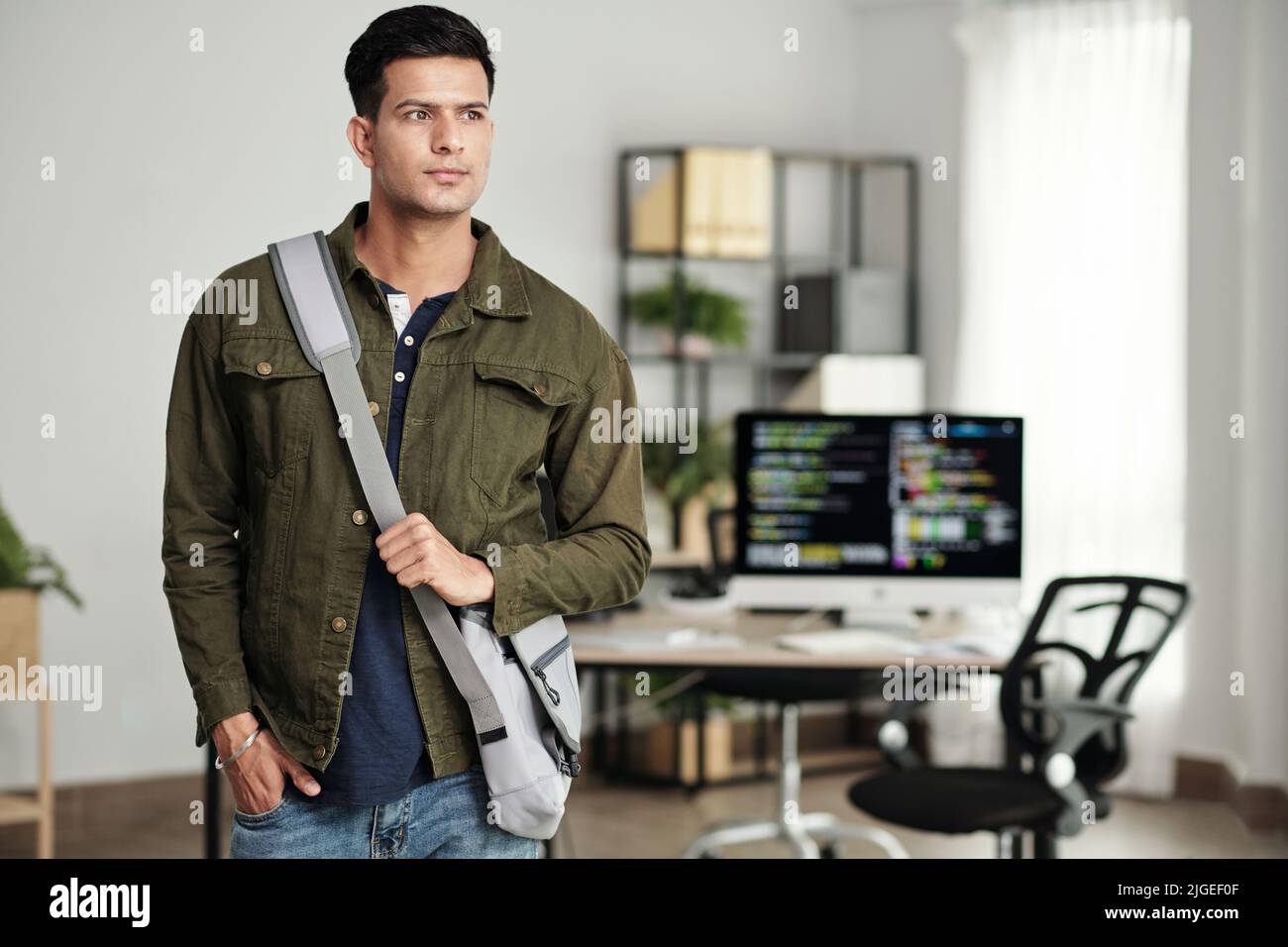 Portrait of young ambitious software developer with cross body bag ...
