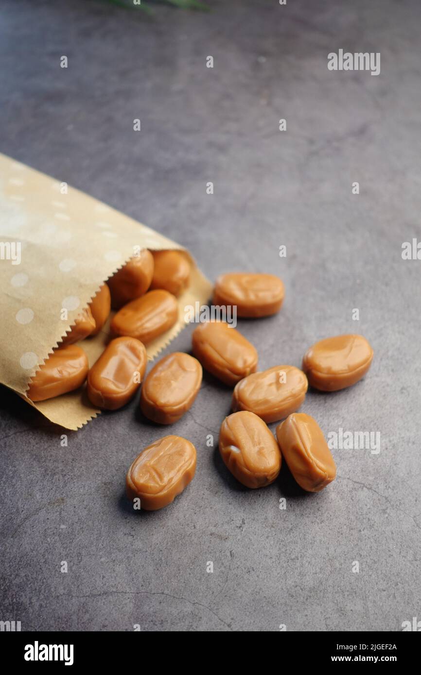 chocolate candy spilling from a packet on black background Stock Photo ...