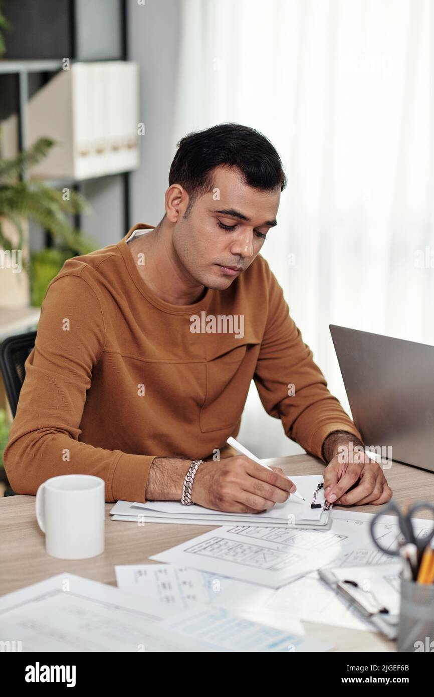 Pensive creative UI designer drawing wireframe for mobile application ...