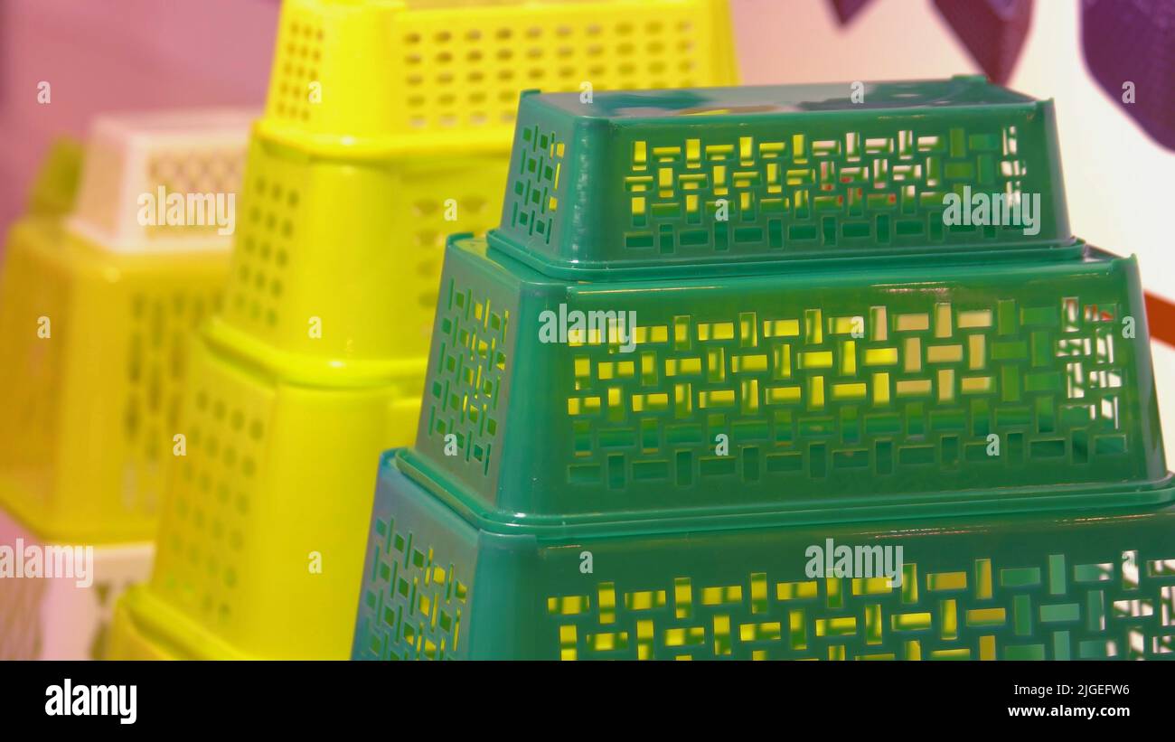 Pyramid of green and yellow plastic baskets. Stack of colorful ...