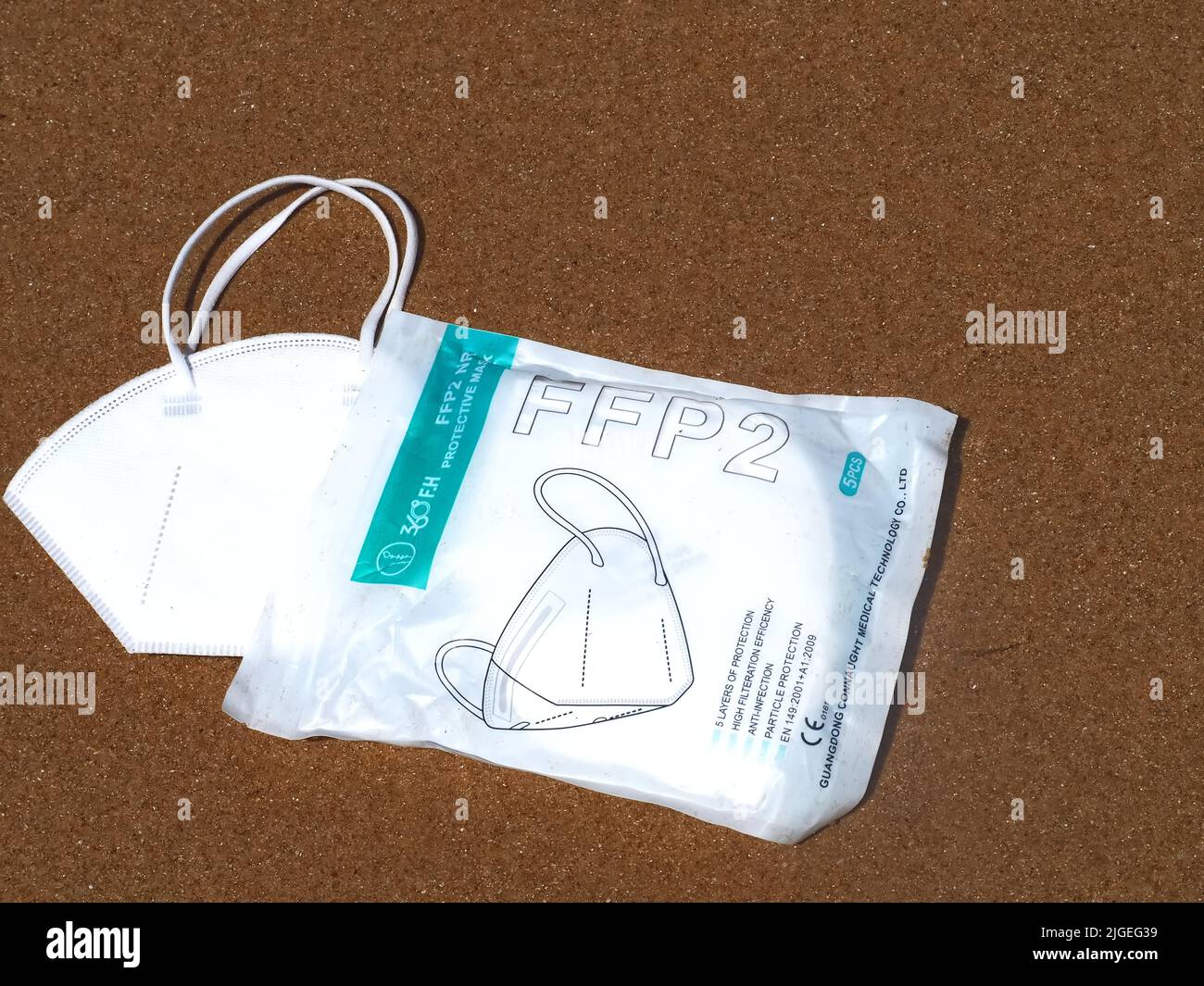 FFP2 face mask on a sandy beach Stock Photo - Alamy