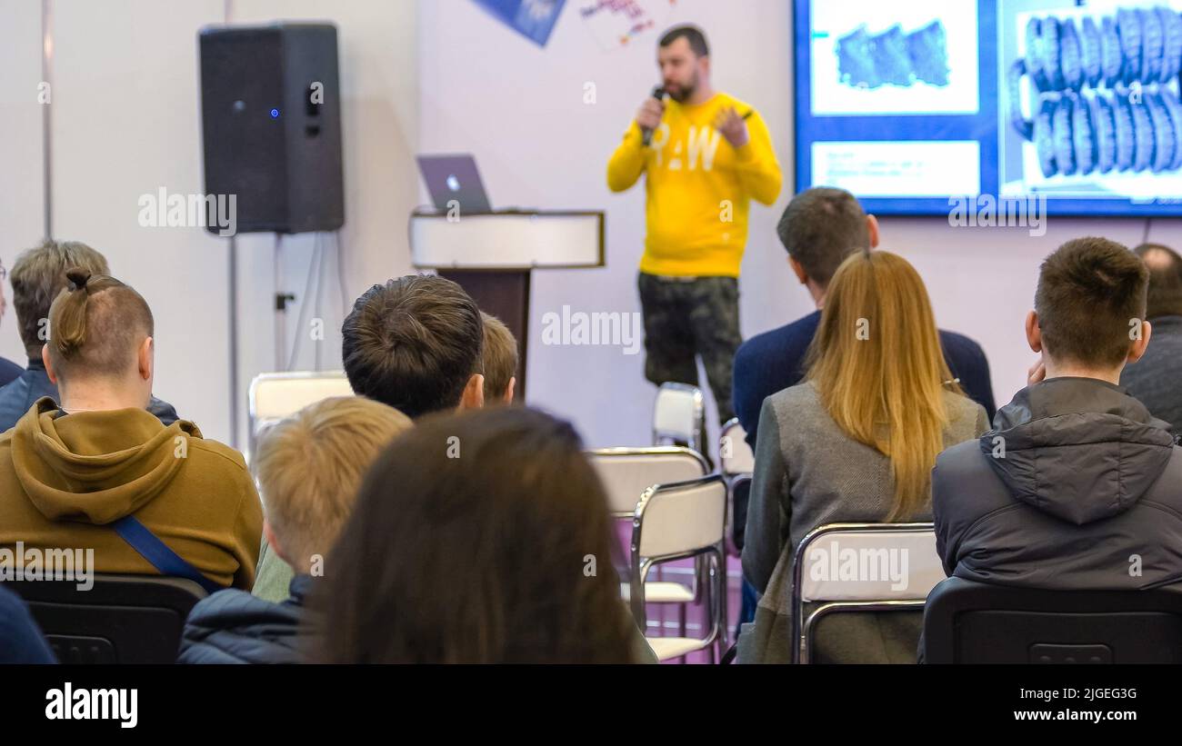 Audience listens to the lecturer at the conference hall. Back view of ...