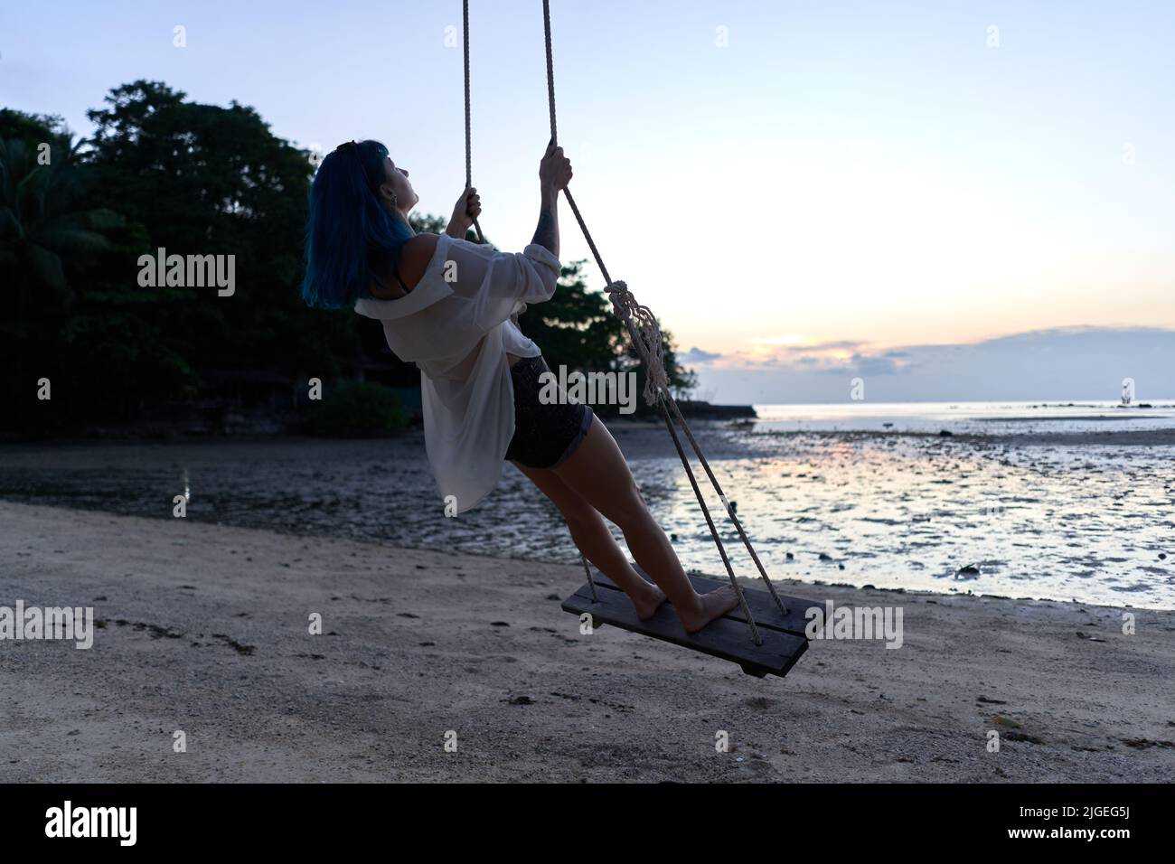 Woman on swing on the beach hi-res stock photography and images - Alamy