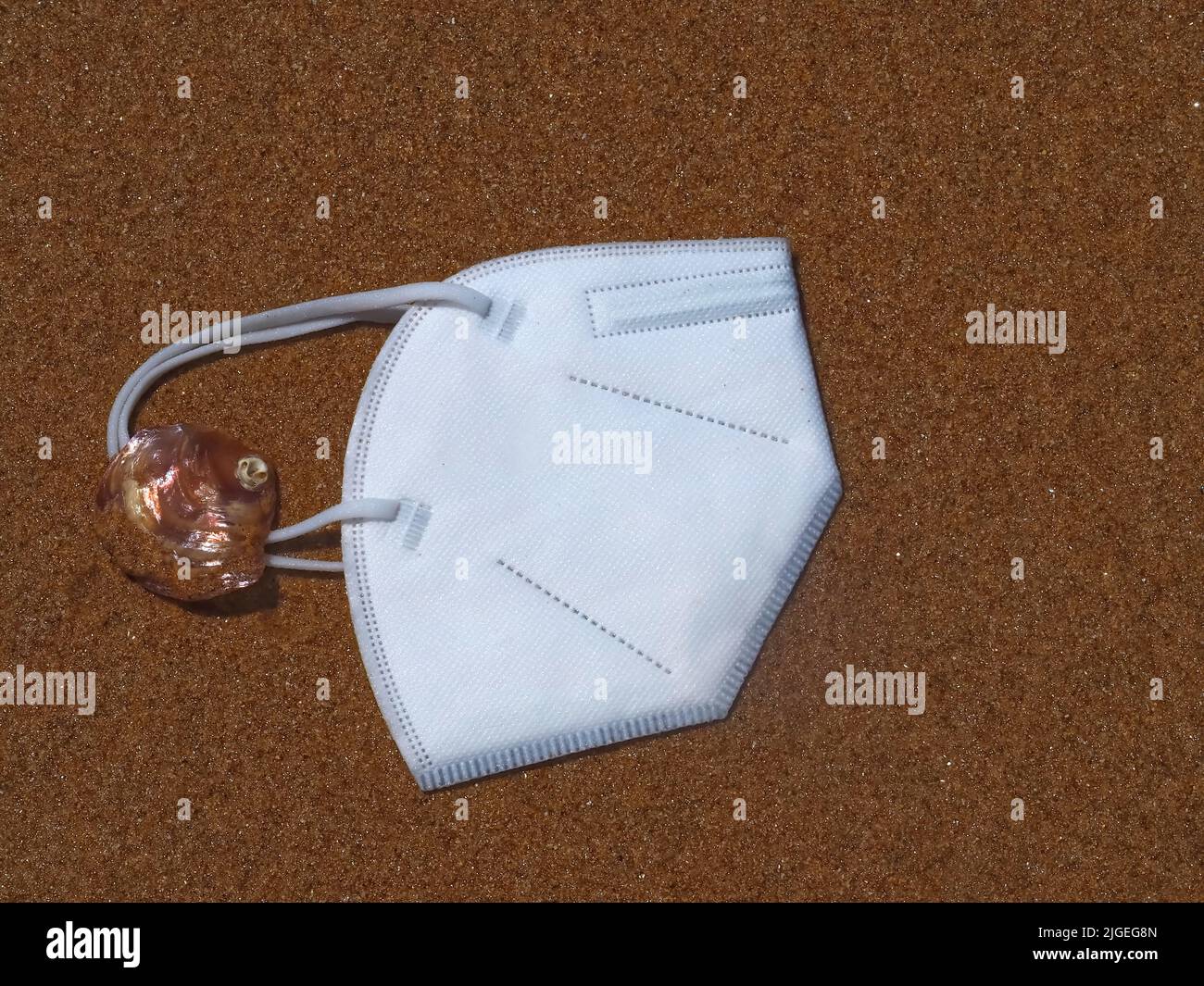 FFP2 face mask on a sandy beach Stock Photo - Alamy